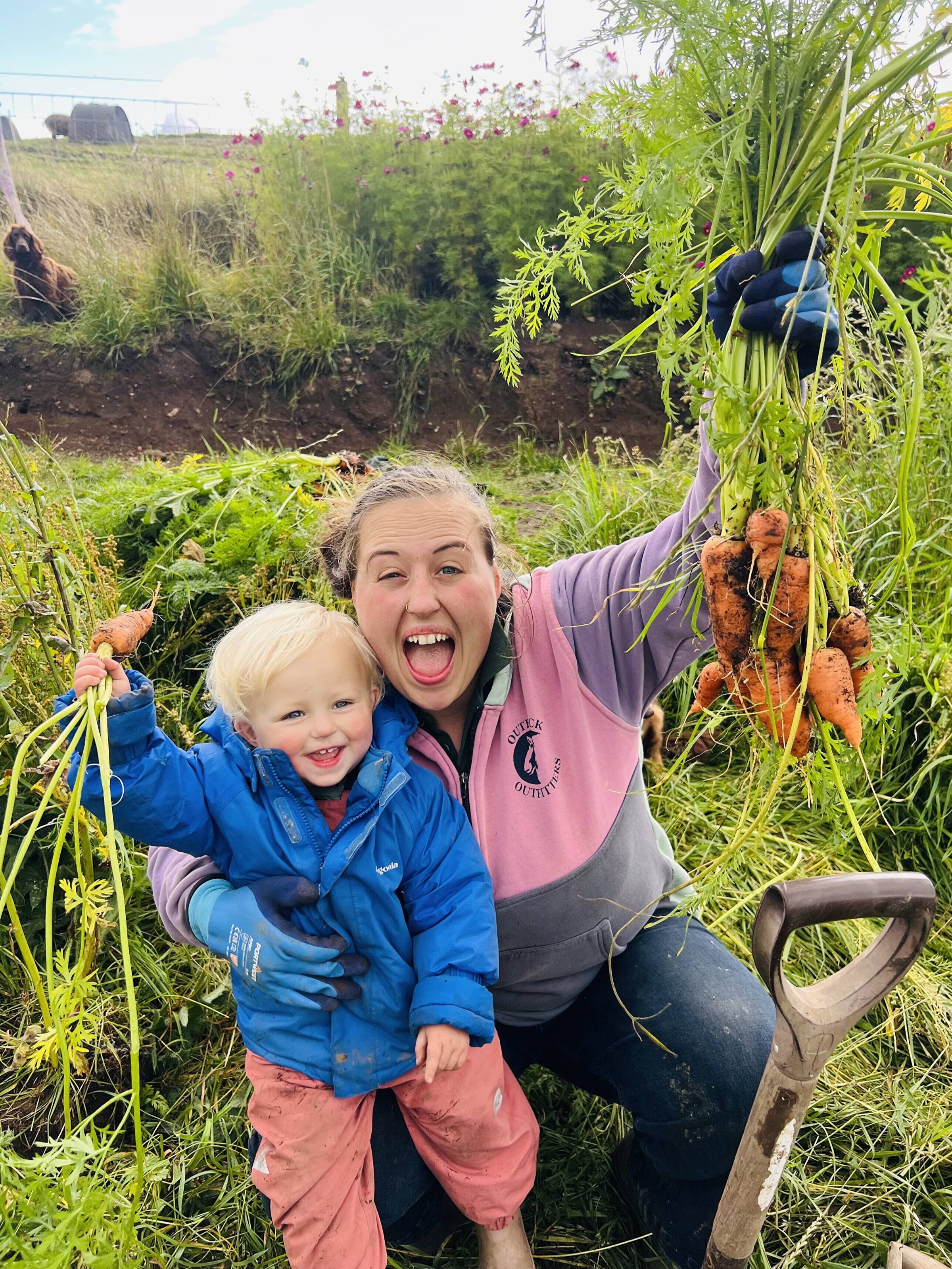 mum and daughter holding farm grown carrots